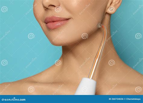 Woman Using High Frequency Darsonval Device on Light Blue Background ...