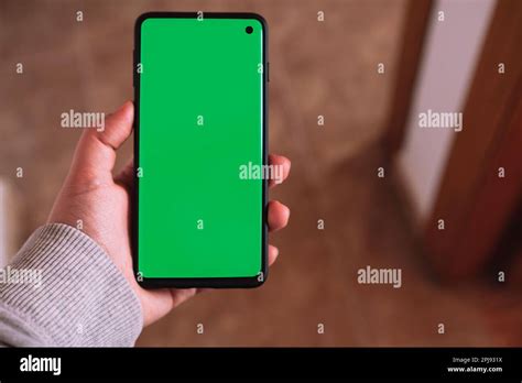 Woman hand showing smartphone green screen. Chroma key phone screen in vertical position. Photo ...
