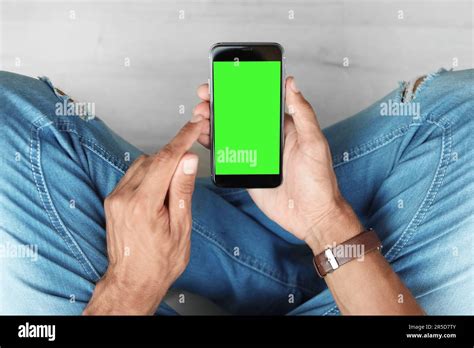 Man using smartphone with green screen, closeup. Gadget display with chroma key. Mockup for ...