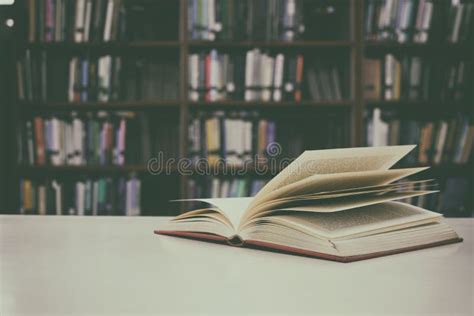 Закройте вверх открытых книги и стога книг на столе с винтажной ...