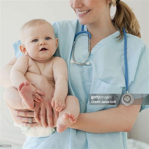 Nurse Holding Baby Girl Smiling High-Res Stock Photo - Getty Images